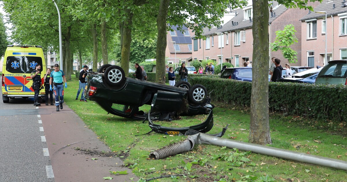 Auto belandt op zijn kop tegen boom na botsing met lantaarnpaal in ...