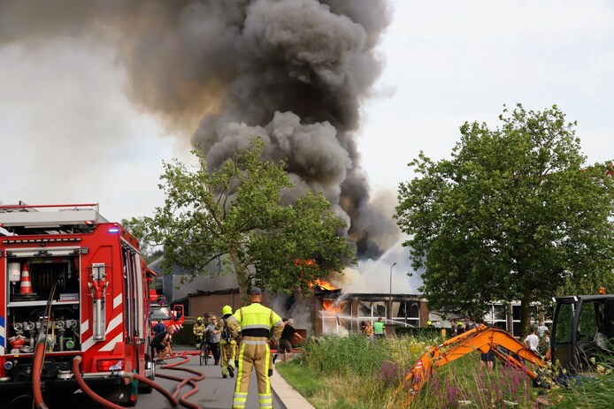 Zeer grote brand legt hal van bouwbedrijf in as, rookpluim in wijde ...