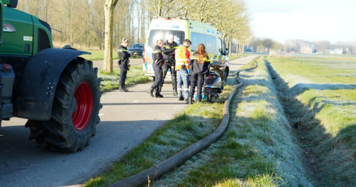 Vrouw rijdt met scooter over slang met mest heen en valt op asfalt bij ...