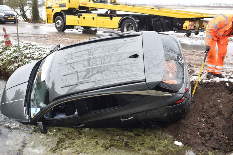 Postbezorger belandt met zijn auto in sloot bij Velddriel door gladheid ...