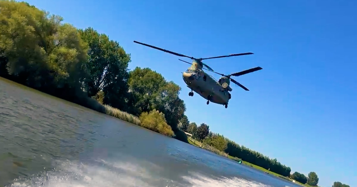 Chinook vliegt laag over het water in Wijk en Aalburg, speedboot kan ’m ...