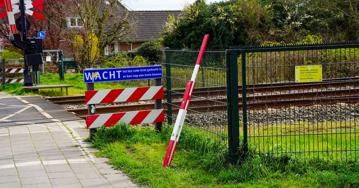 Spoorboom breekt af en ligt over trottoir bij overweg in Berghem ...